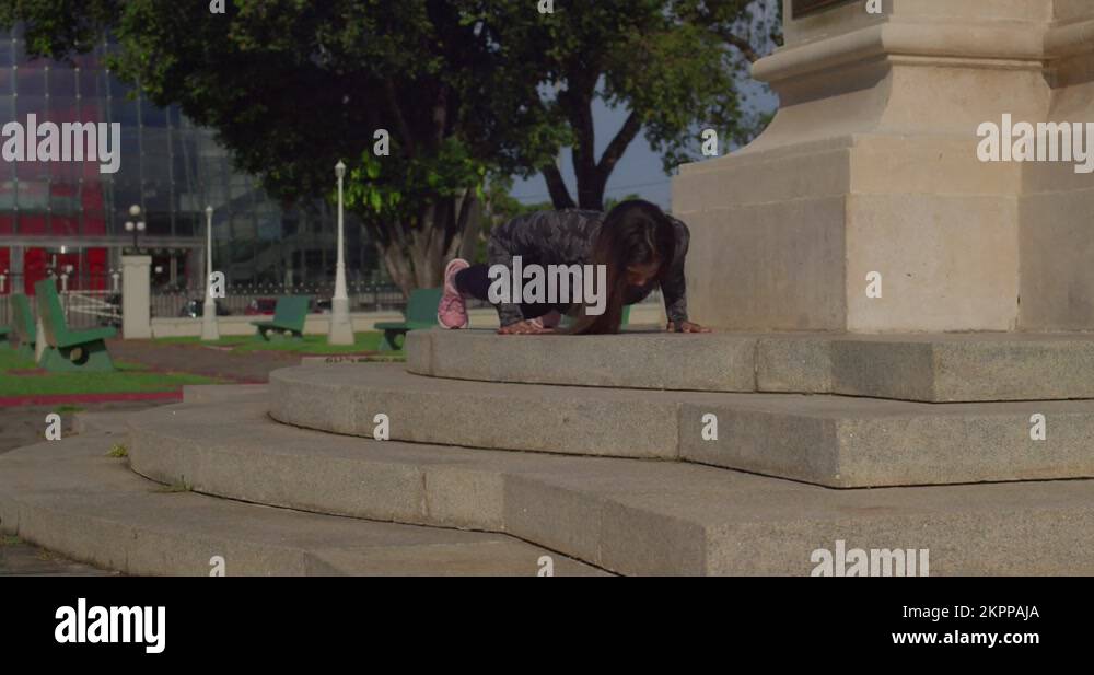Fitness model push up exercises in a city park on the Caribbean island ...