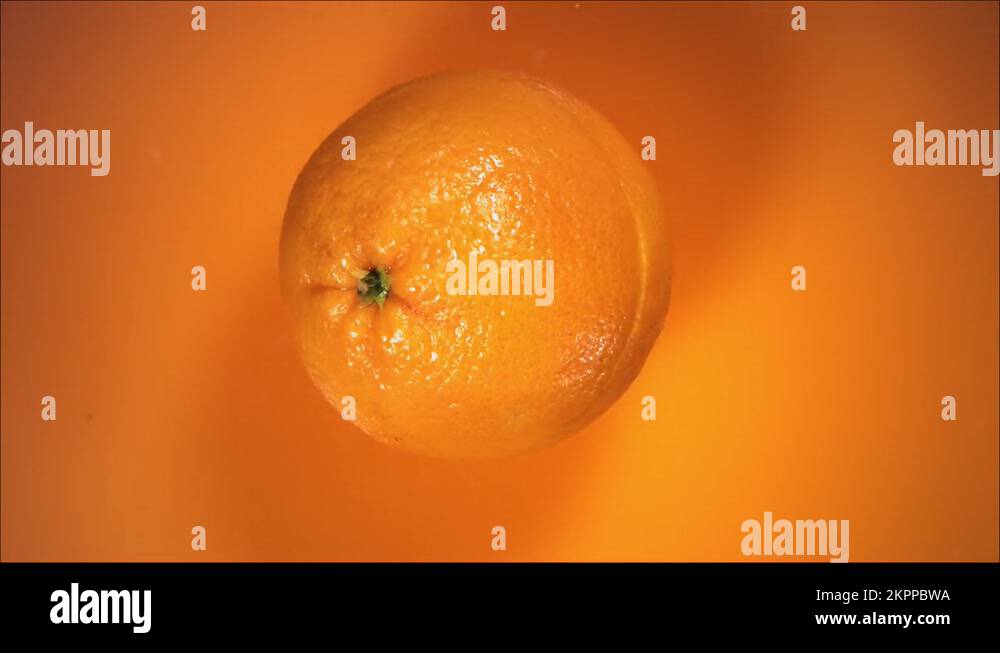 Orange Fruit falling on juice with splash and divided in half Stock ...