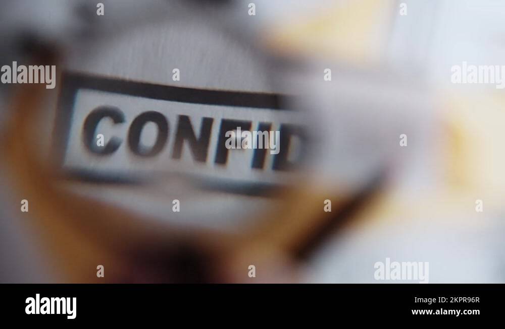 Confidential stamp revealed by magnifying glass moving across paper or ...