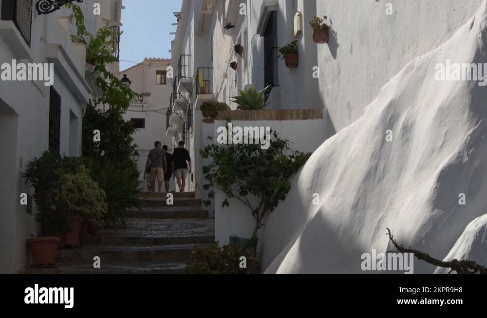 People walking in a andalusian whitewashed street at sunset. Tilt Stock ...