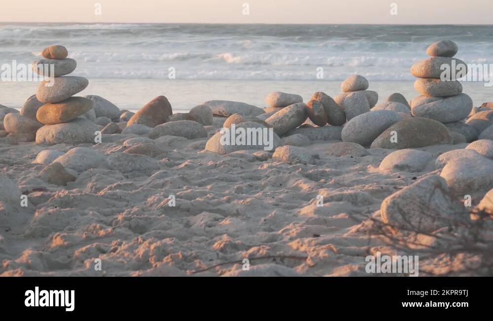 Rock balancing on pebble beach. Pyramid stacks of stones, ocean coast ...