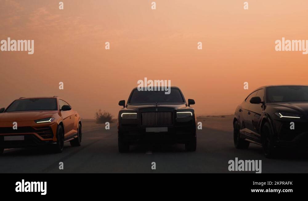 Rolling shot of Rolls Roys Cullinan Lamborghini Urus car driving in ...