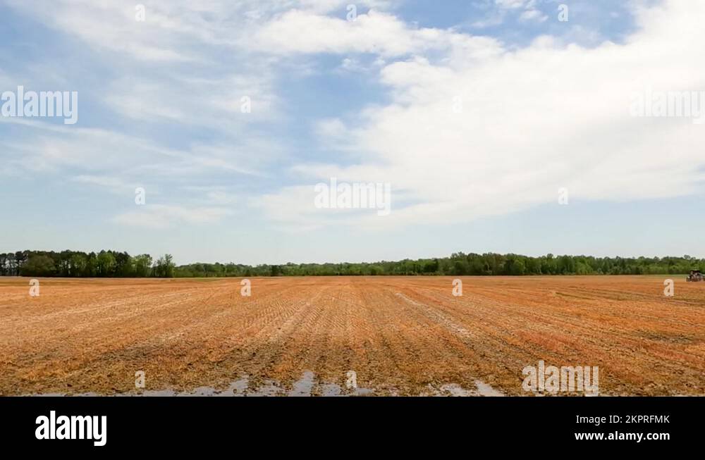 Pan of tractor cultivating farmland in rural Georgia fresh soil Stock ...