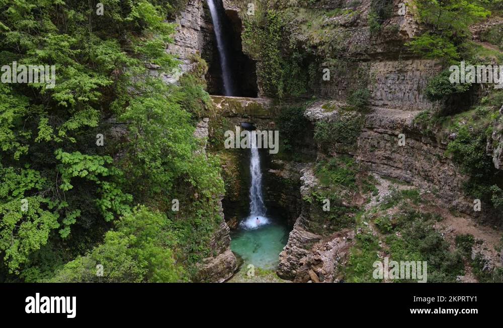 A man swimming in the Ujëvara e Peshturës waterfall in Albania Stock ...