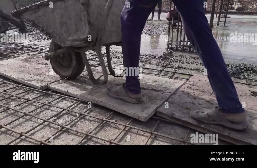 Construction workers pouring concrete using the wheelbarrow or Concrete ...