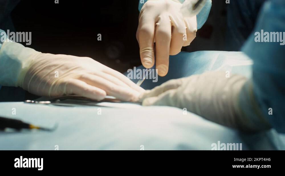 A team of surgeons perform an operation in a bright operating room ...