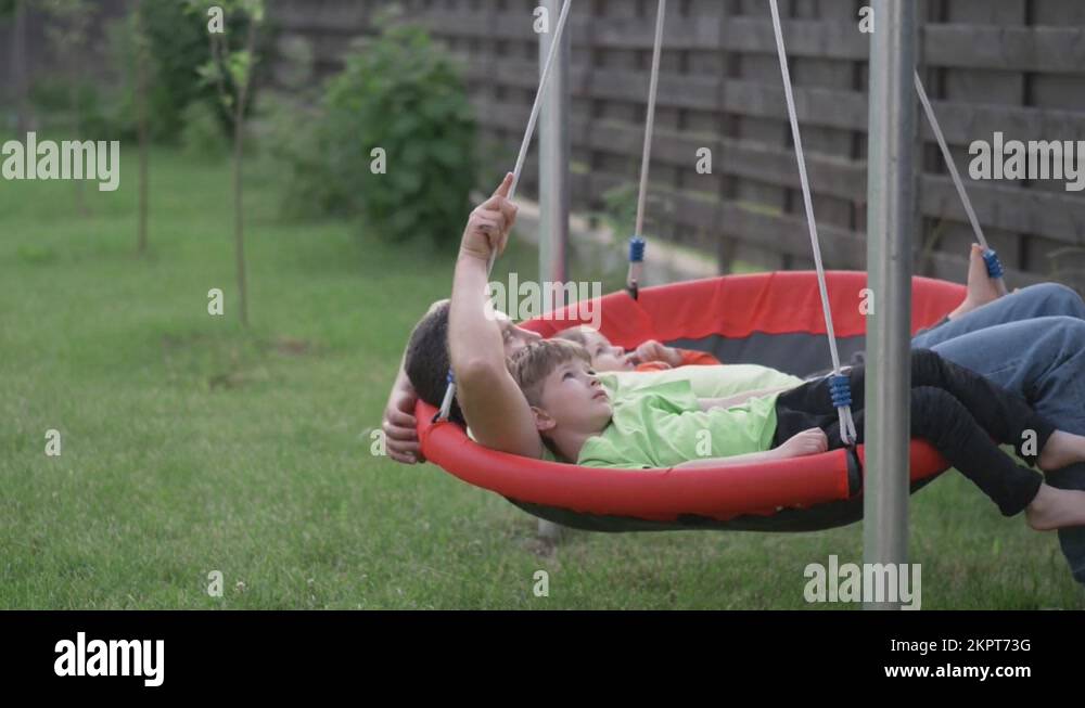 Man and his two little sons lying down all together and spinning around ...