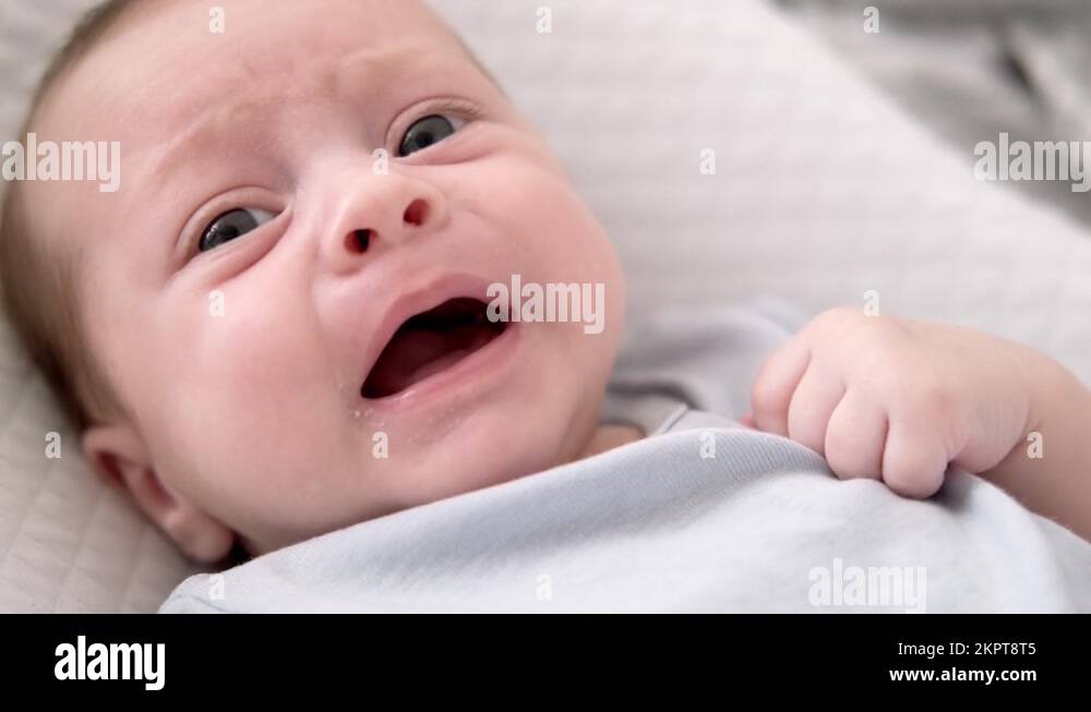 Dissatisfied, crying, upset, sad Newborn baby boy lying in nursery ...