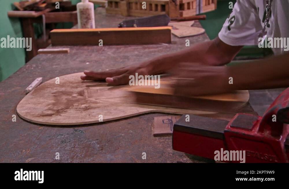 Luthier or guitar maker hand sanding the face of an acoustic guitar ...