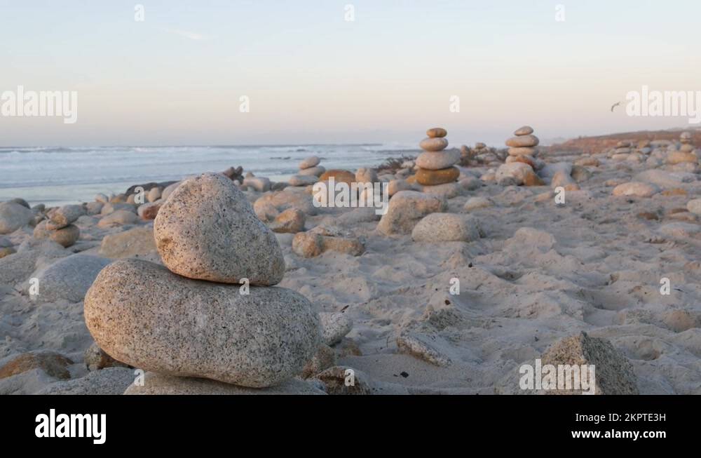 Rock balancing on pebble beach. Pyramid stacks of stones, ocean coast ...
