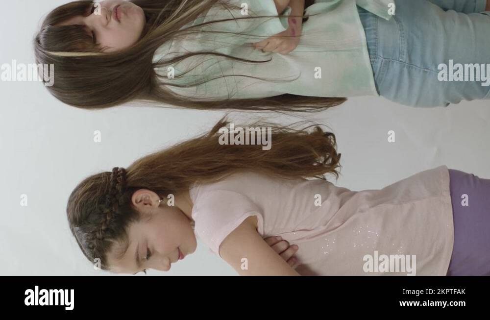 Two little girls are fighting with each other on a white background ...