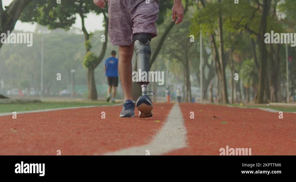 Disabled Athlete walking forward with prosthetic leg at running track ...