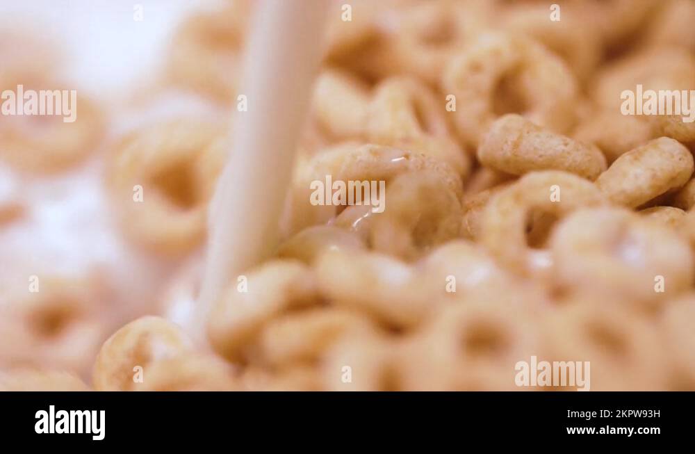 Pouring milk into a bowl full of loop shaped breakfast cereal Stock ...