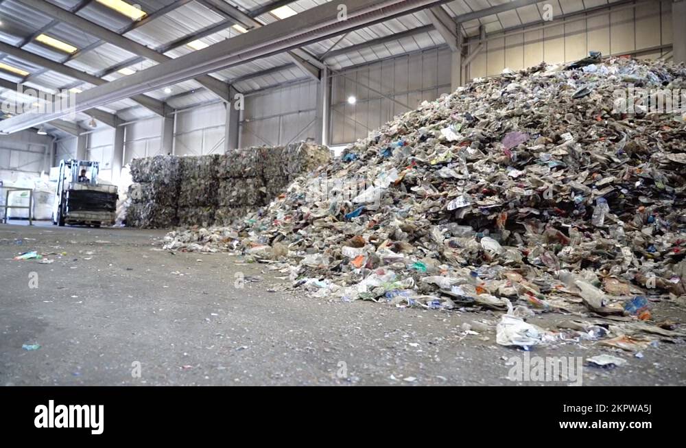 Piles of plastic waste in a recycling plant passed by a forklift Stock ...
