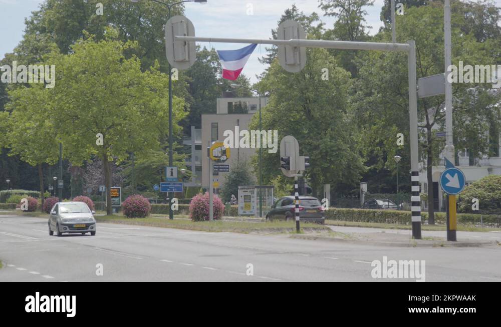 Wide view of Upside down Dutch flag hanging on traffic light. A sign of ...