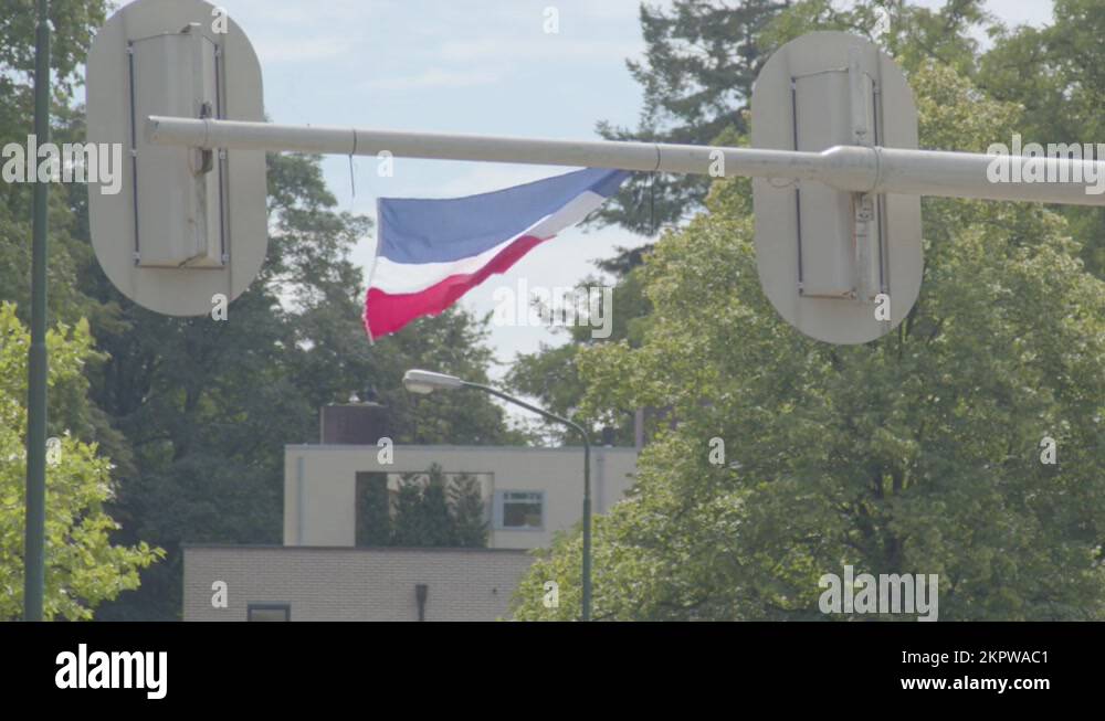 Close up of Upside down Dutch flag hanging on traffic light. A sign of ...