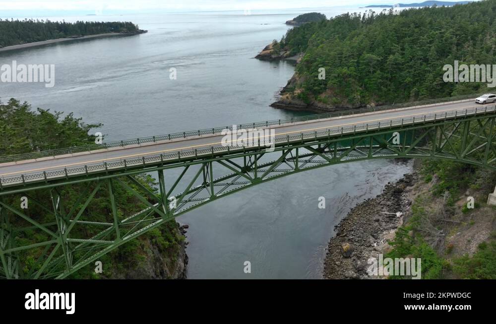 Drone perspective of a single car driving across Deception Pass in ...