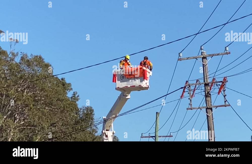 Men working on electrical cables at height using an elevated work ...
