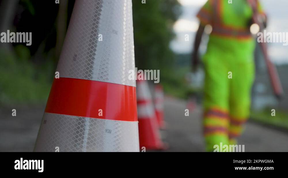 Road Construction Flagger Walking with Stop / Slow Sign Past Traffic ...