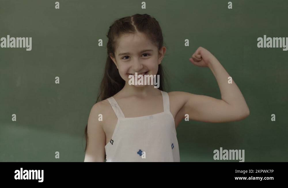 Little girl shows her arm muscles to the camera Stock Video Footage - Alamy
