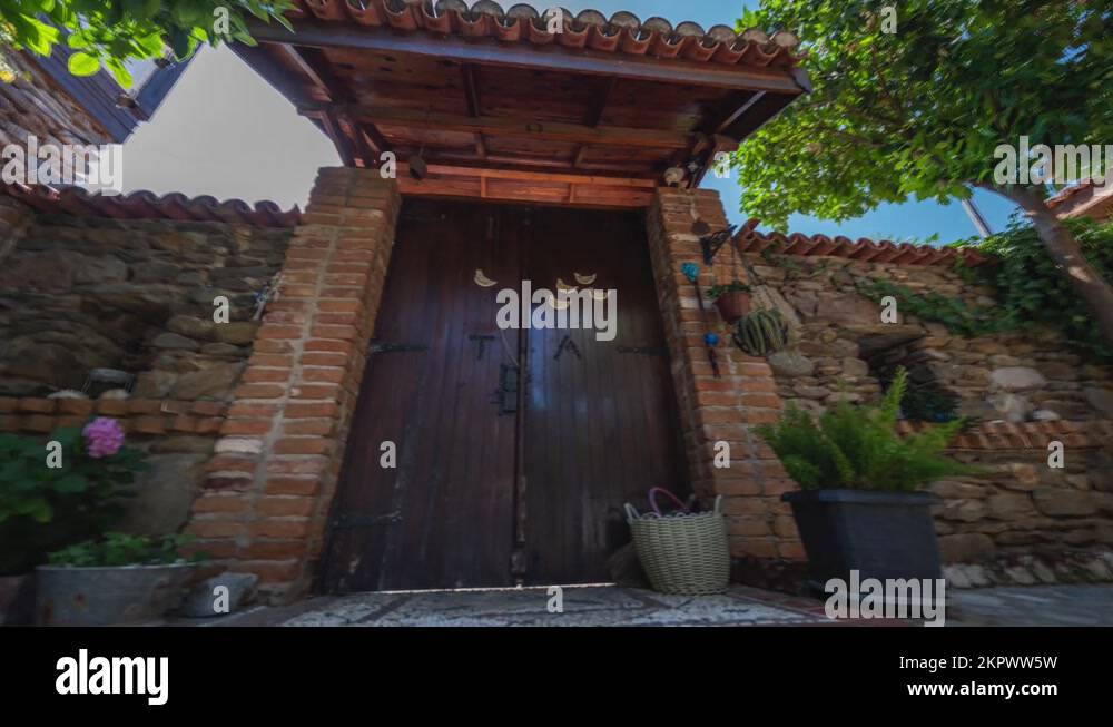 Wooden door in a traditional, authentic stone house garden. time lapse ...