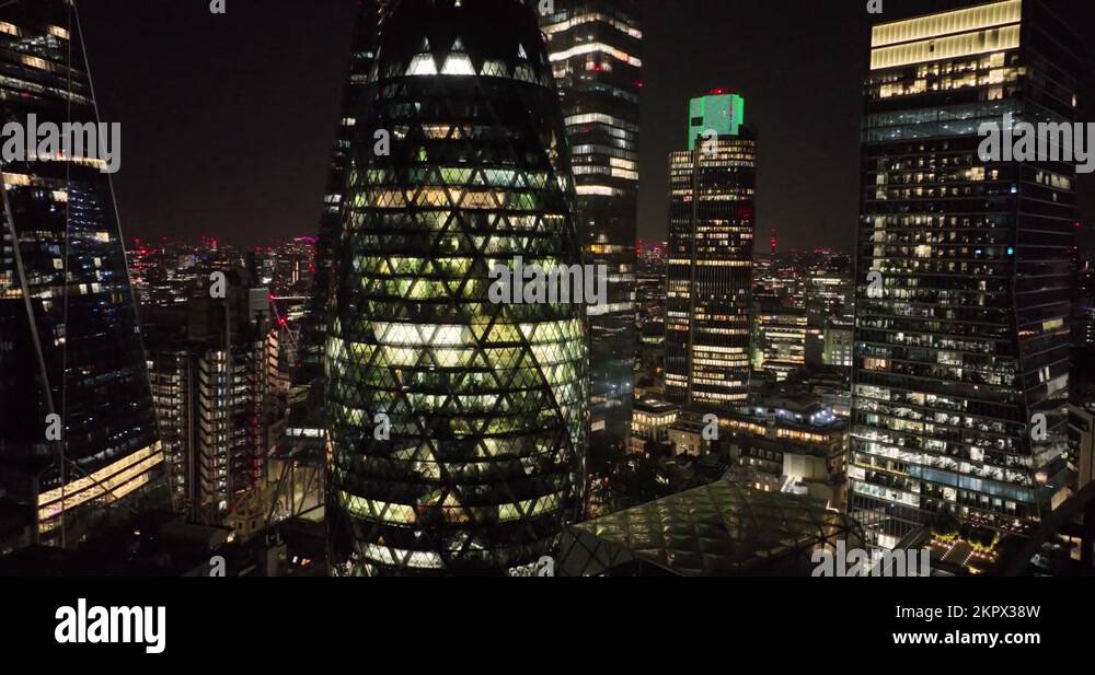 Close up The Gherkin along iconic tower in the business center at night ...