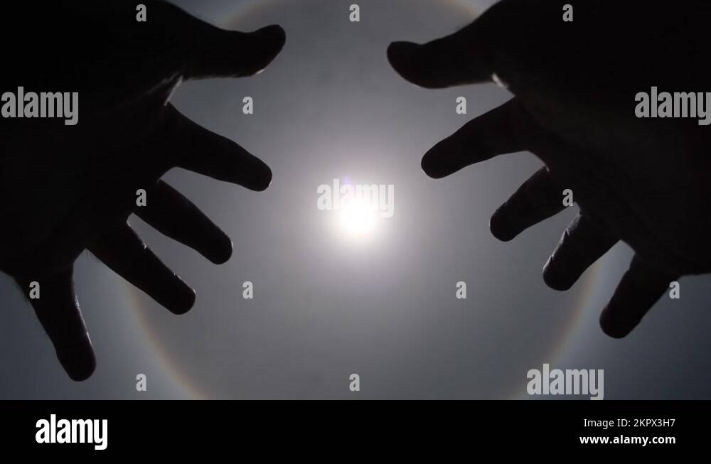 Phenomenon, sun halo. Sun with a circular rainbow and shadows of hands ...
