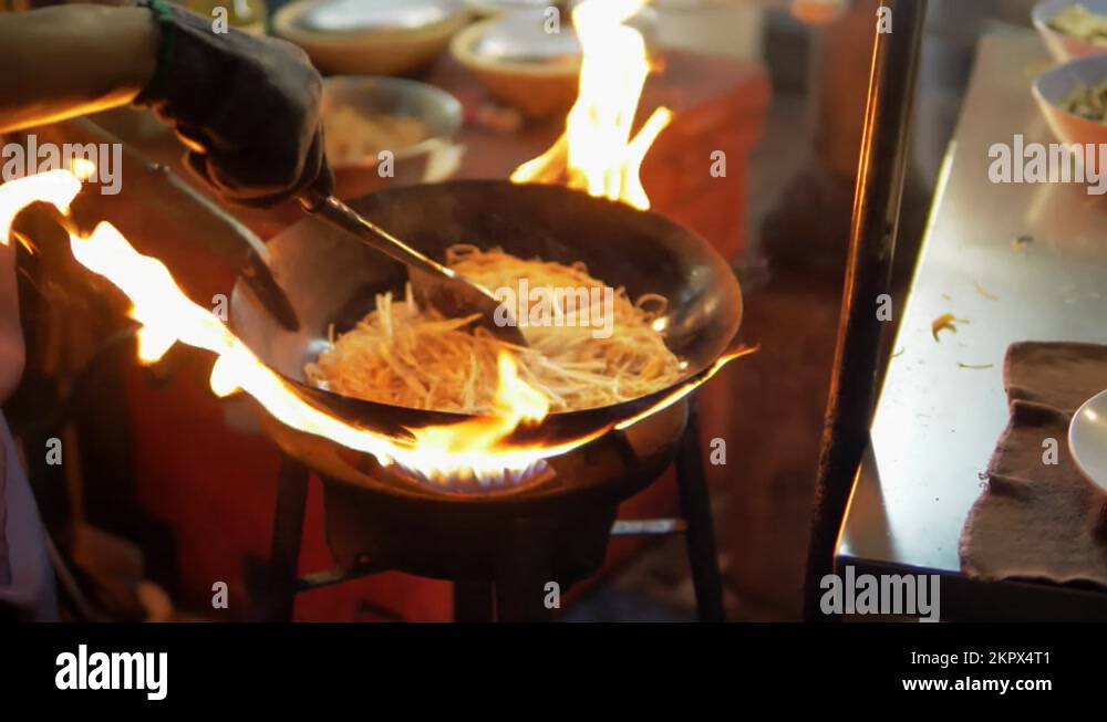 Chinese style fried noodle in a pan with wok fire in downtown Yaowarat ...