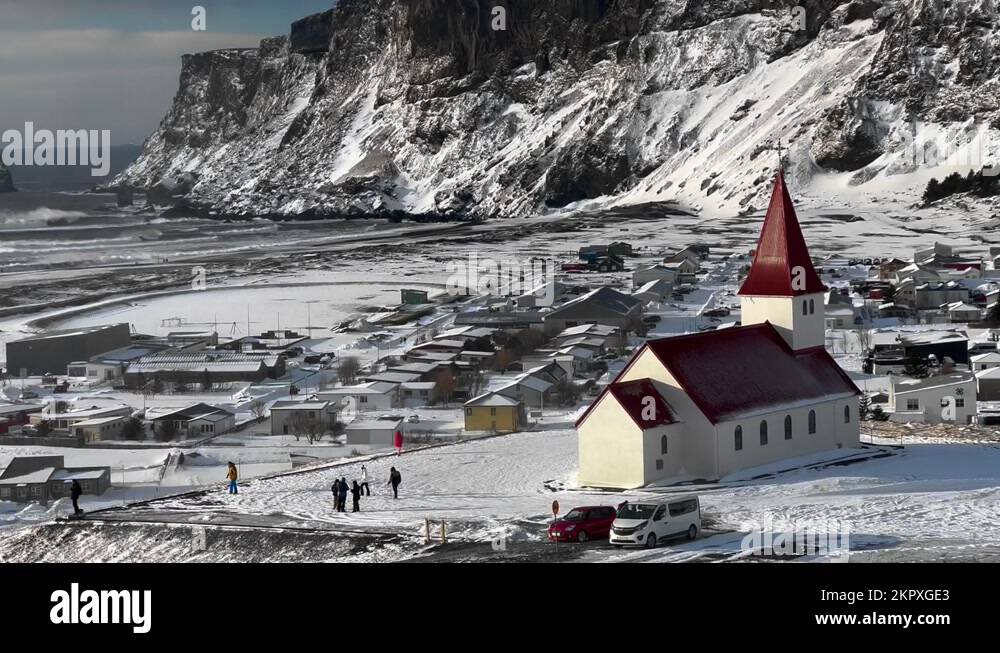 Panorama shot of Vík í Mýrdal Village during snowy winter with ocean in ...