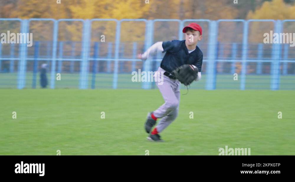 Baseball tournament at school, the boy pitcher catches a fastball in ...