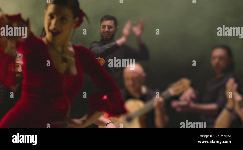Woman dancing spanish style dance . Group of men playing on guitar and ...