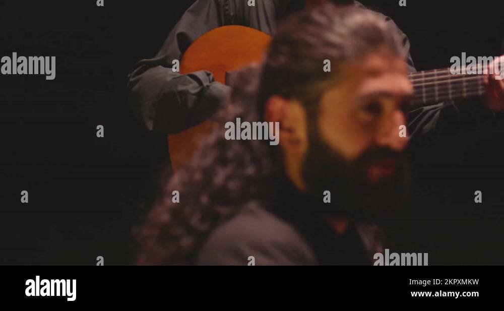 Woman dancing spanish style dance . Group of men playing on guitar and ...