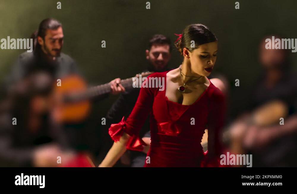 Woman dancing spanish style dance . Group of men playing on guitar and ...
