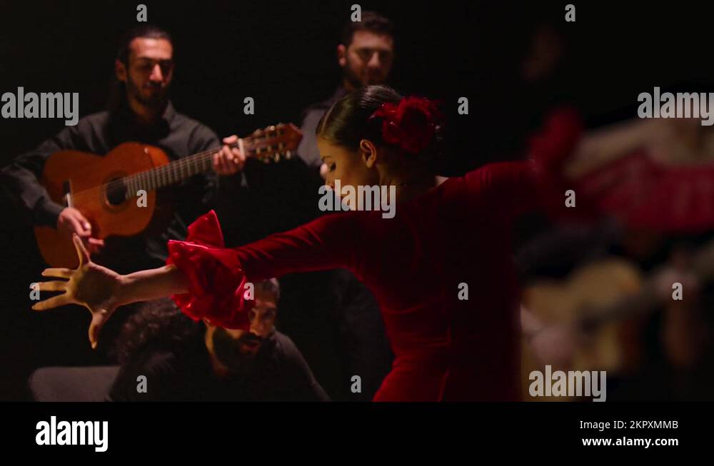 Woman dancing spanish style dance . Group of men playing on guitar and ...