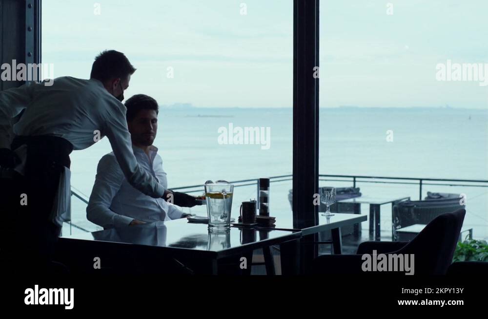Relaxed businessman resting hotel terrace at lunch break. Waiter ...
