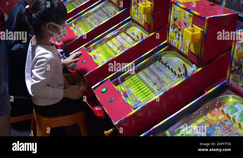 Little girl playing famous childhood game pinball with excitement to ...