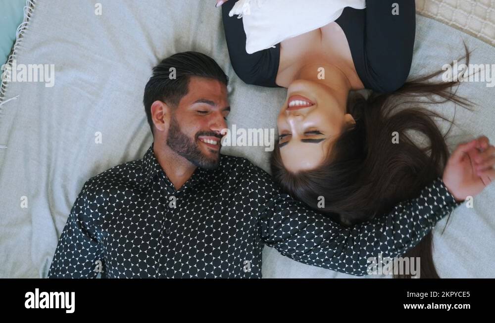 Love between two people. Happy heterosexual married couple lying on bed ...