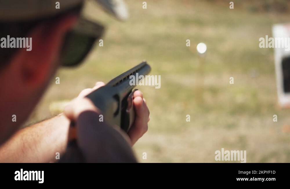 Caucasian man strikes target firing a pump-action shotgun at an outdoor ...