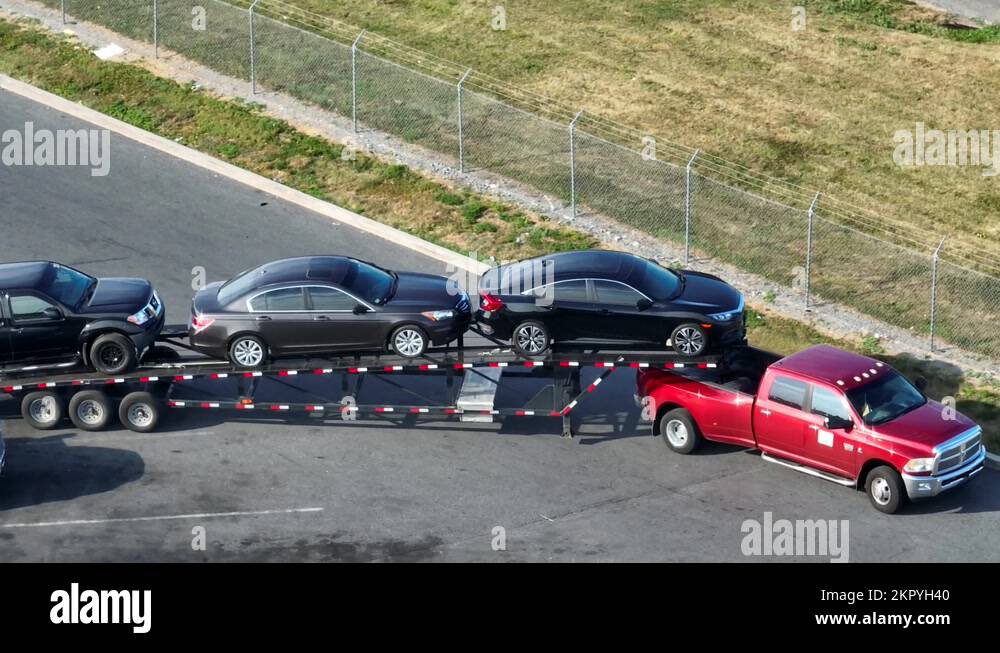 Pickup truck pulling full car carrier trailer. Sedans and truck being ...