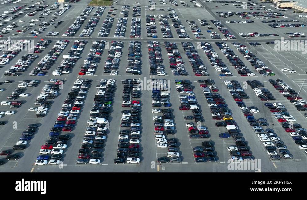 High aerial pull back and tilt up revealing sprawling parking lot at ...