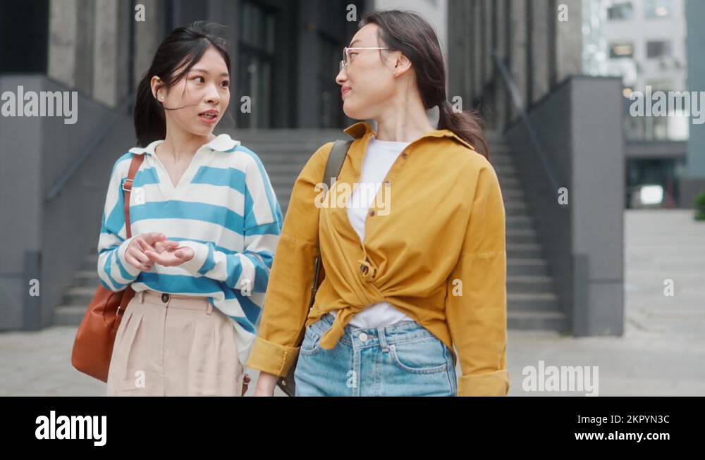 Pretty young ladies with brown hair talking and walking with background ...