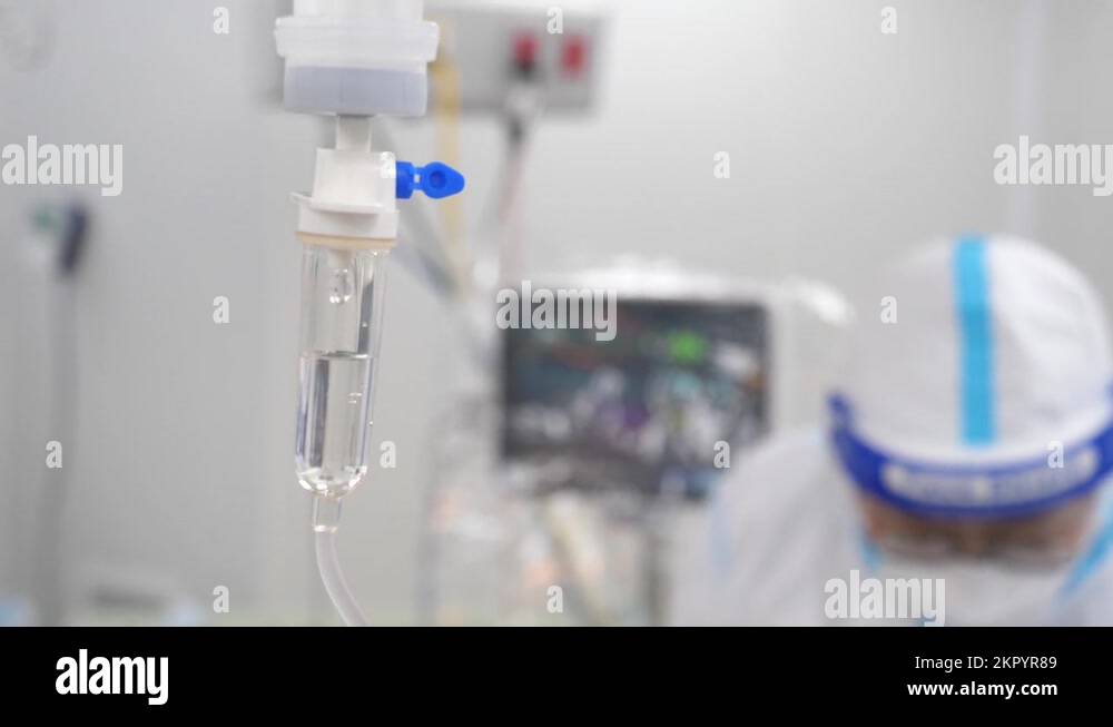 IV Drip In Tube With Doctor Wear Infection Control Gown In Background ...