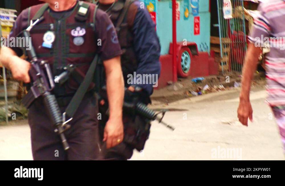 Armed police in black uniforms patrol the favela in Rio de Janeiro ...