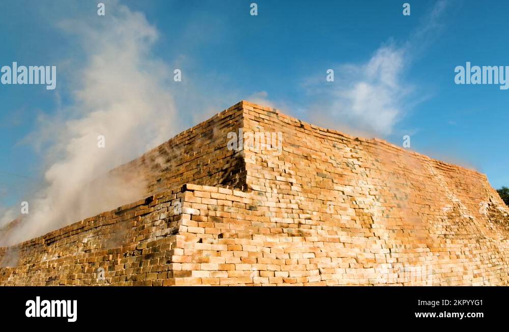 Clamp kiln with clay-bricks being fired, gases emitted cause air ...