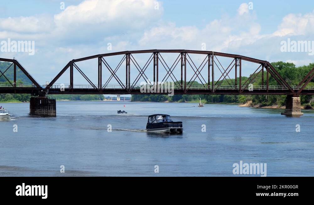 Boats travel on the Mississippi River travel under a railroad bridge ...