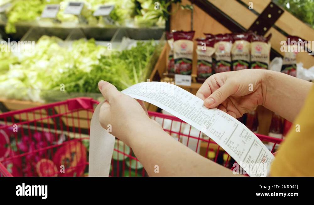 Woman checks paper check after shopping for groceries at mall by ...