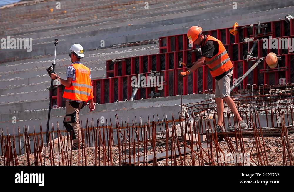 Pouring concrete to a metal structure. Workers make a reinforced ...