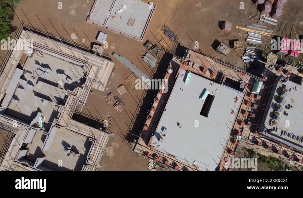 Rotating descending aerial view of the early stages of new build houses ...
