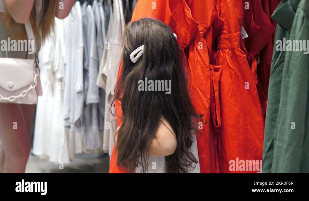 Beautiful Customer with her Children is shopping at a clothing store ...