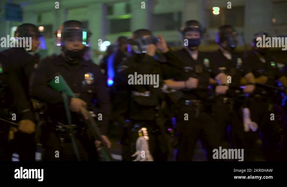 A line of riot police stands in front of a group of BLM protesters in ...